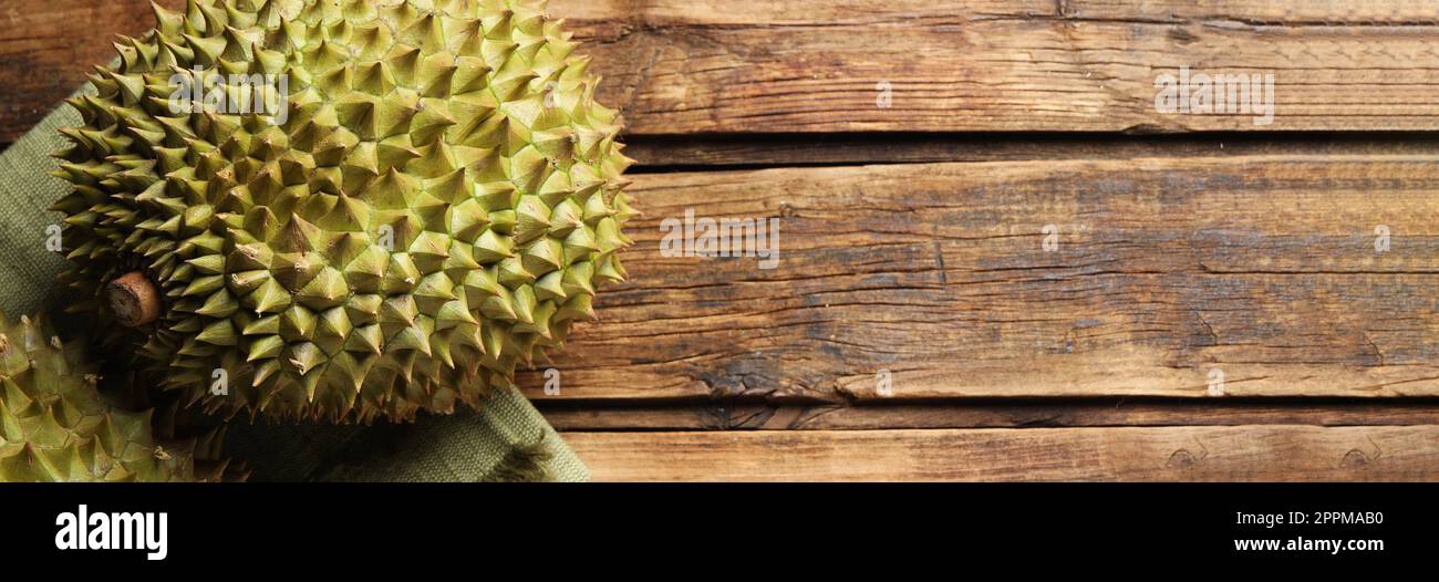 Ripe durians on wooden table, top view with space for text. Banner ...