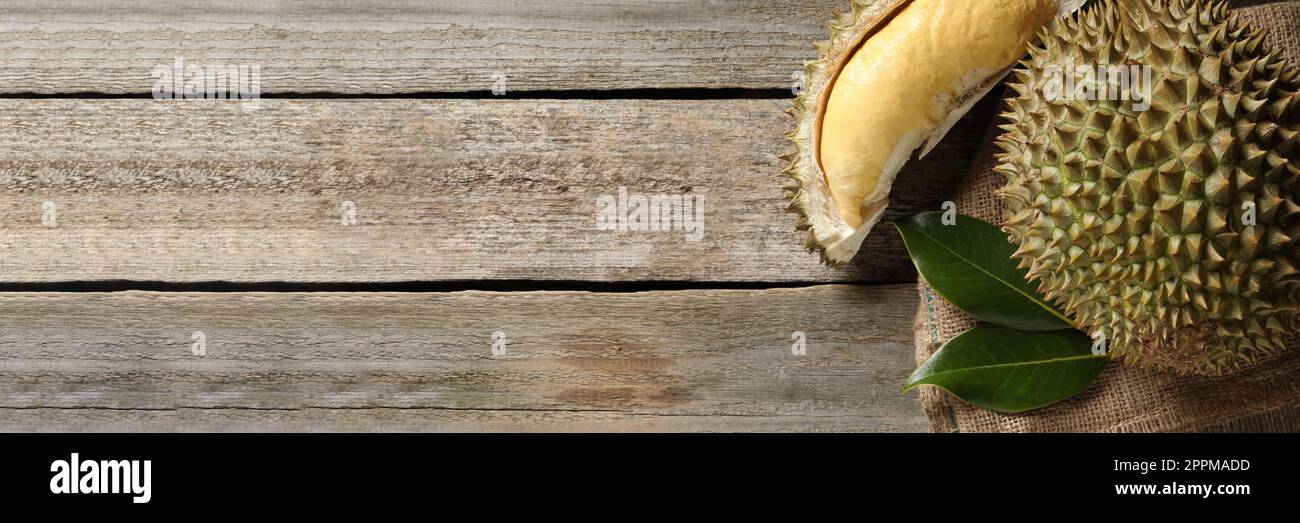 Fresh ripe durian fruits on wooden table, top view with space for text ...