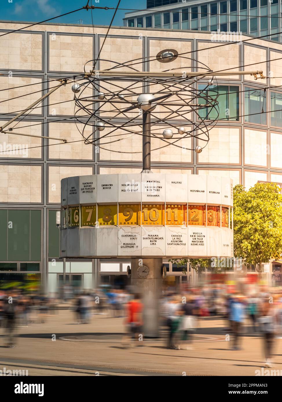 Famous world clock at Alexanderplatz, Berlin, Germany, with people walking in front, long ...