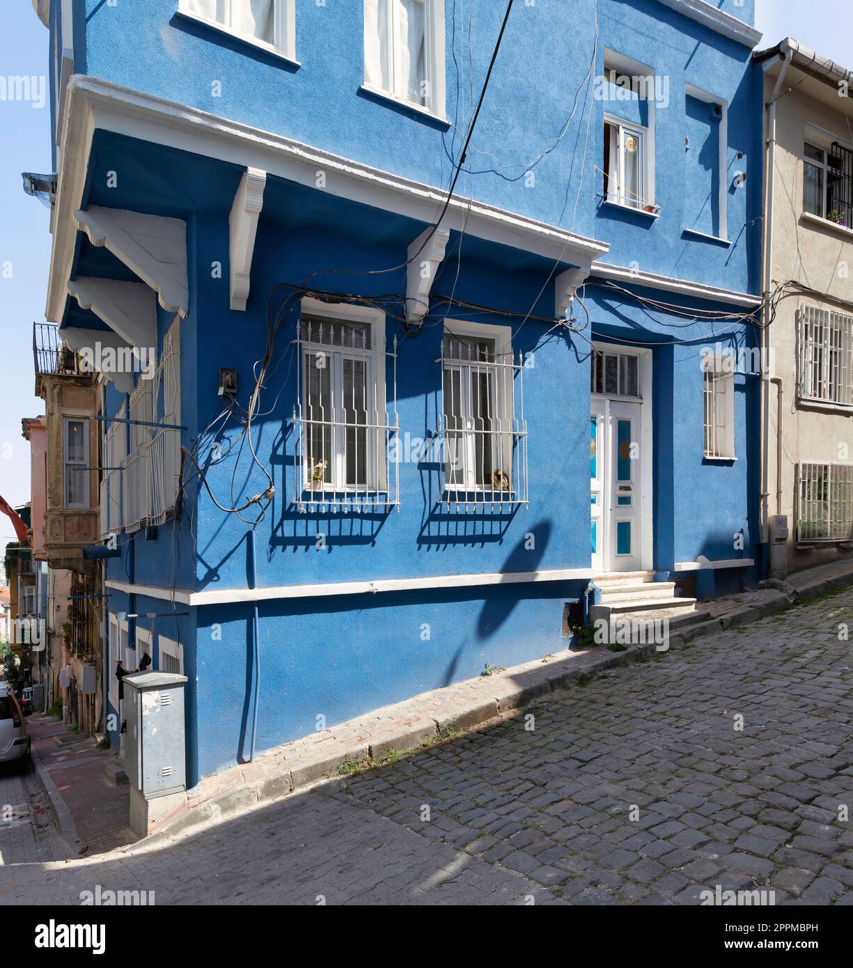 Cobblestone alley with beautiful old traditional blue house in Balat ...