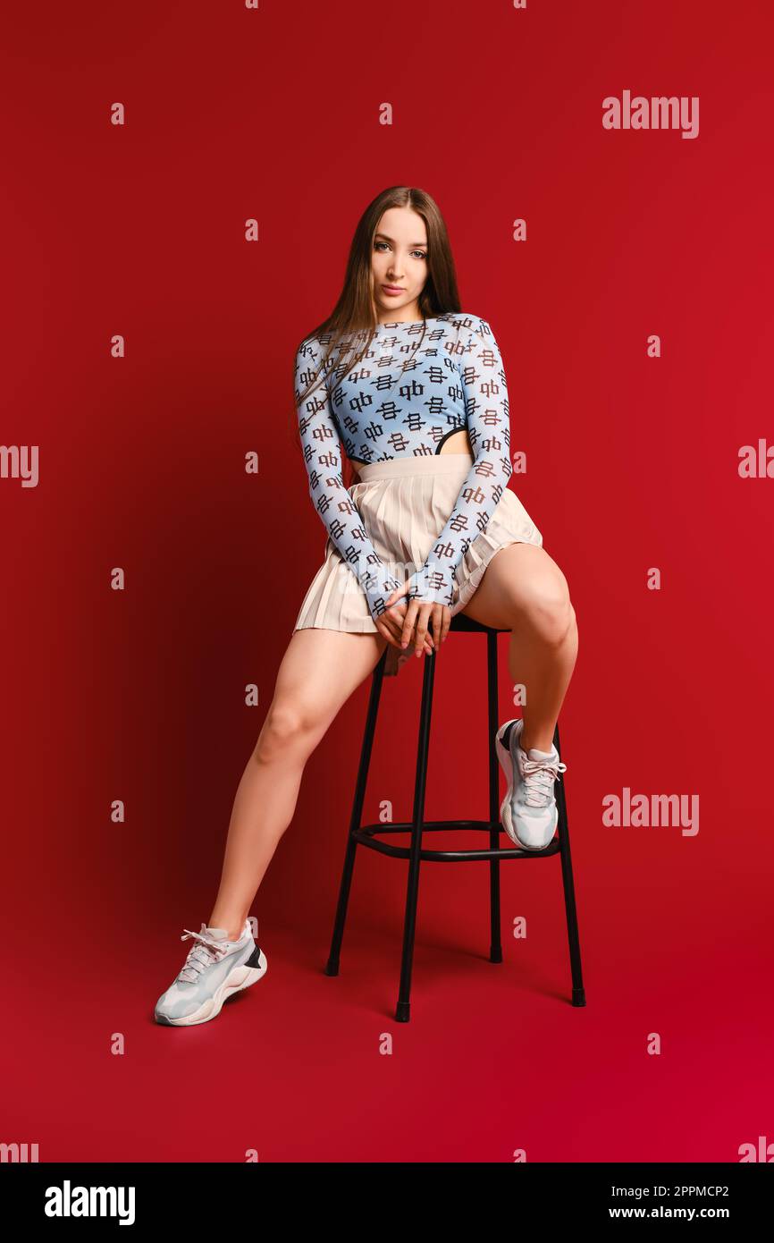 A vibrant portrait of a sporty young woman sitting confidently on a ...