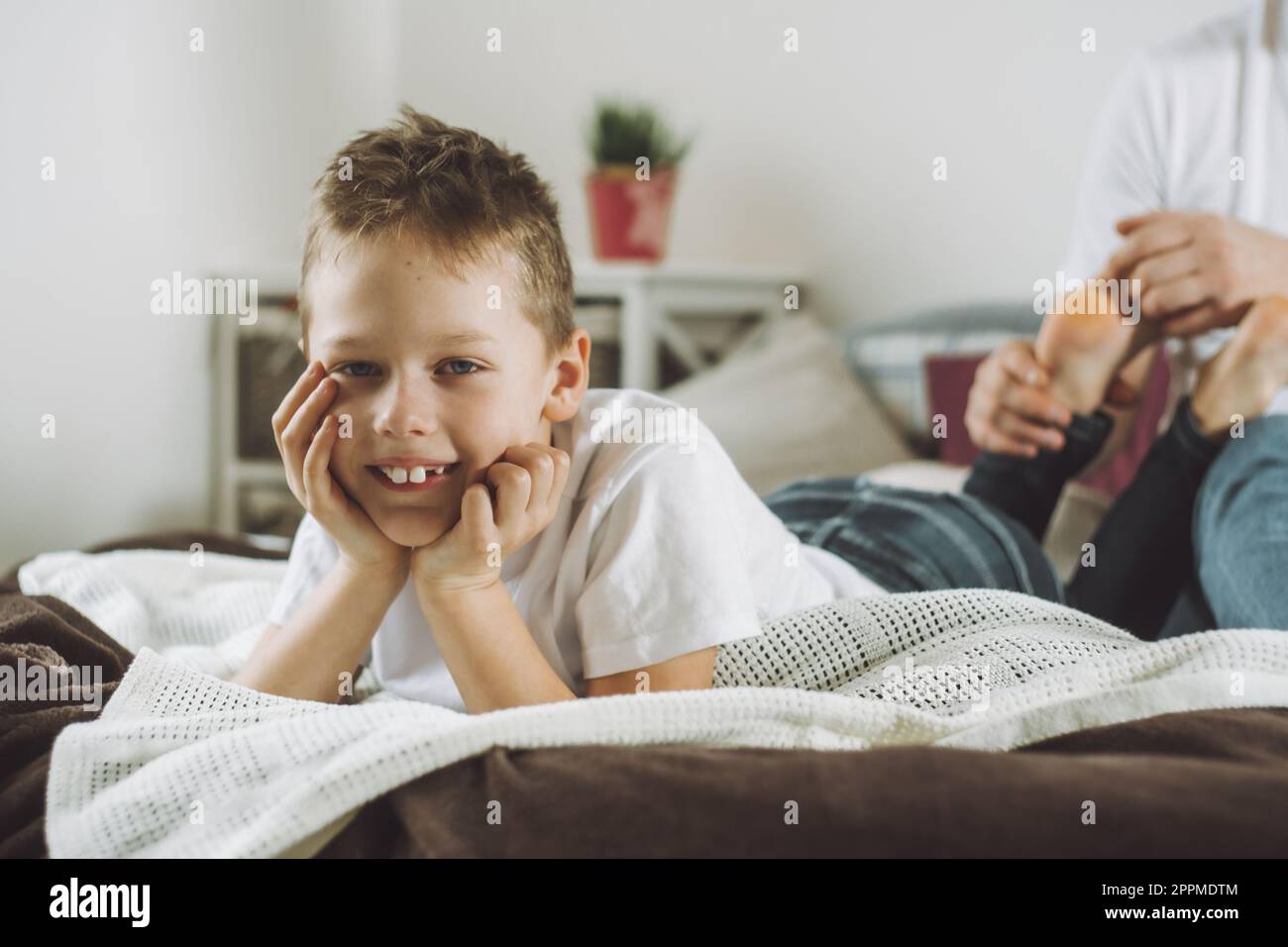 Father plays with his son 7-10 on bed. Dad tickles kids feet. Family ...