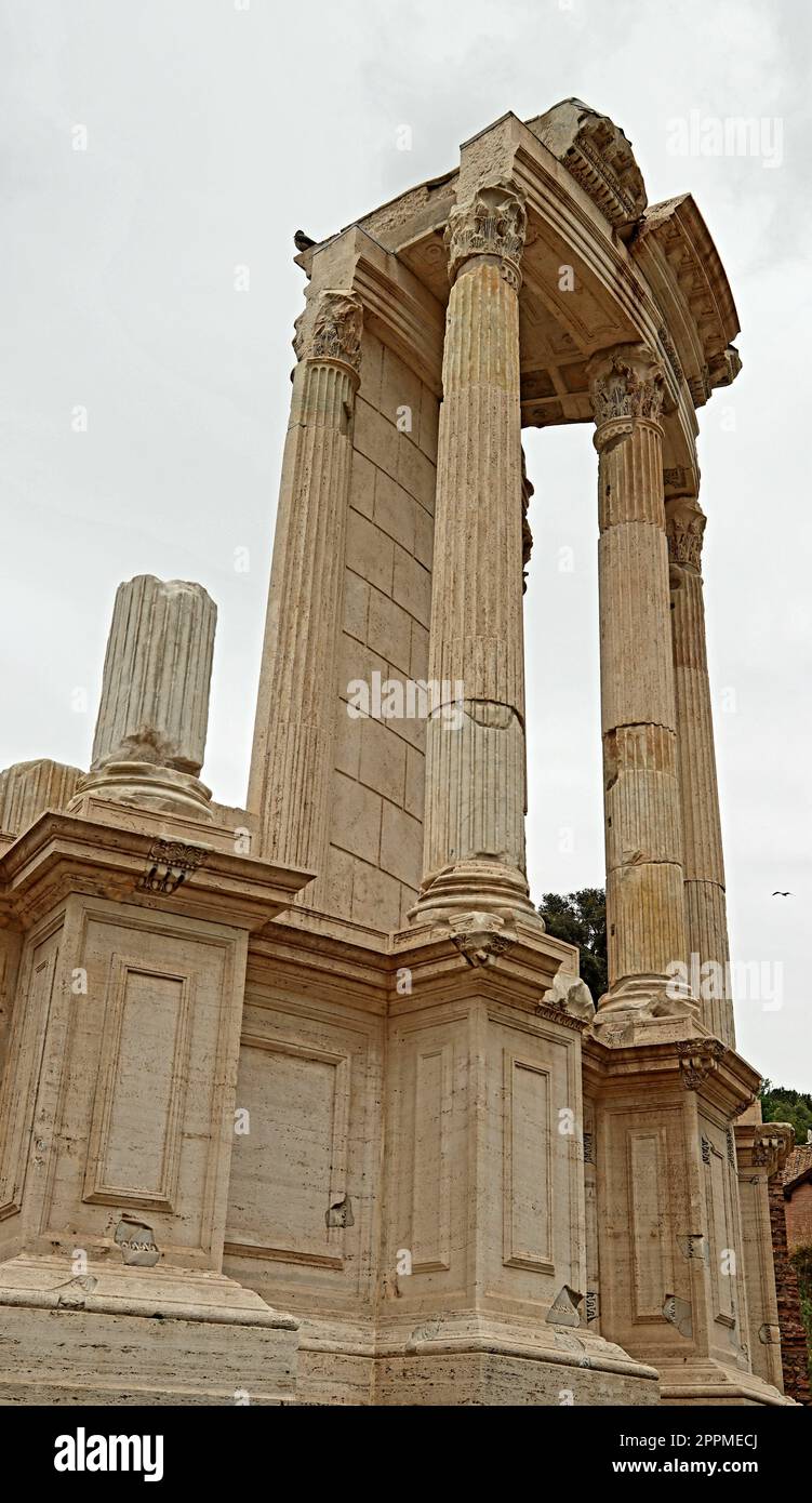 An aged Roman temple in ruins, with crumbling pillars, arches and walls ...