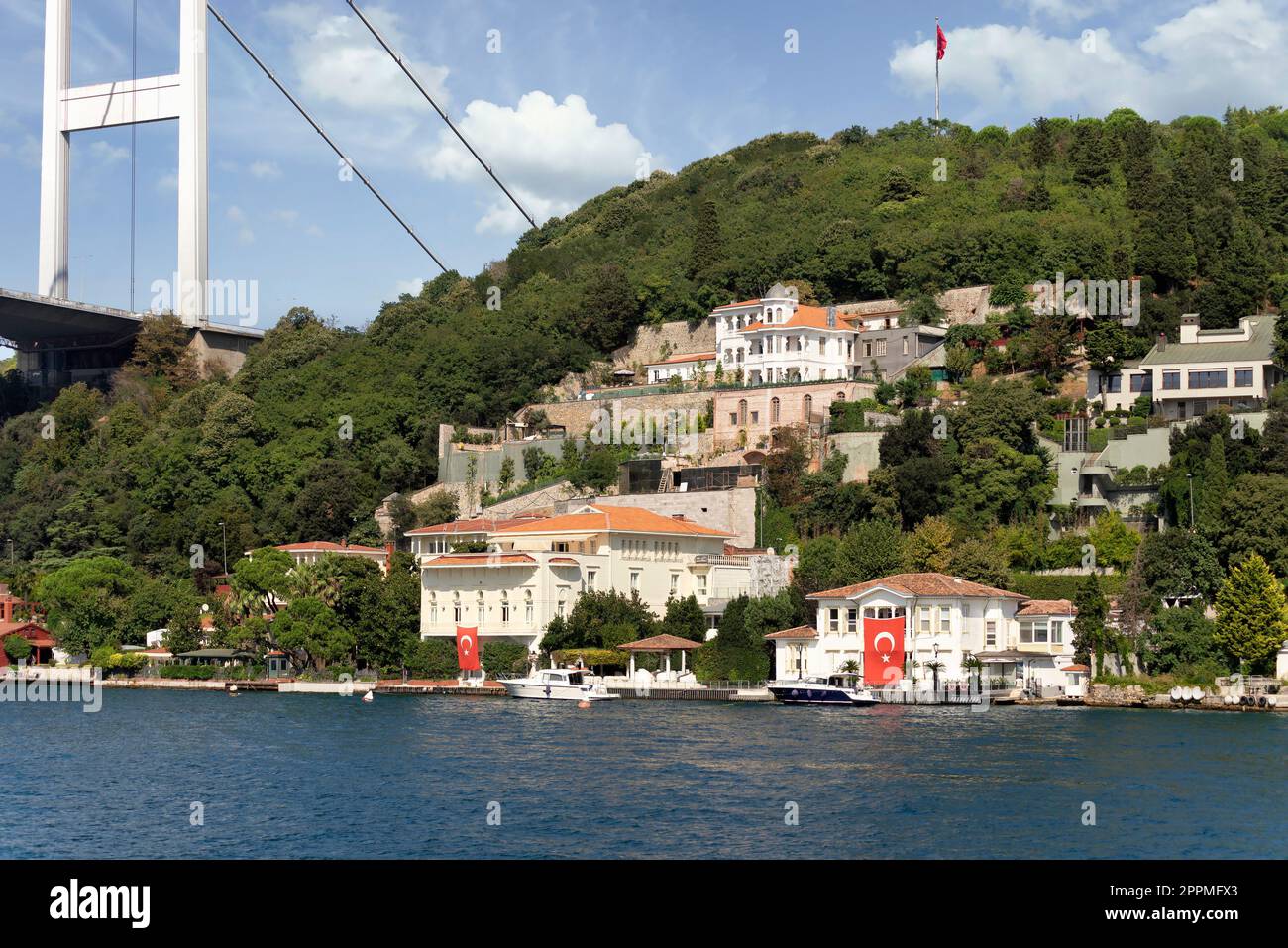 Traditional waterfront houses, Bosphorus bridge, and green hill with ...
