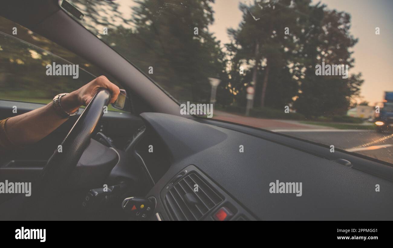 Hands of a driver on a wheel of a car (motion blurred image Stock Photo ...