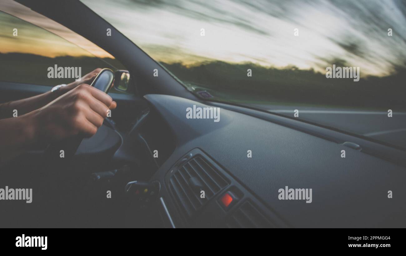 Hands of a driver on a wheel of a car (motion blurred image Stock Photo ...