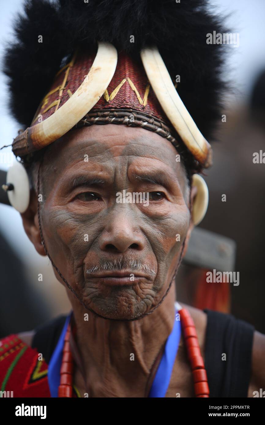 A Konyak elder with tattooed face in festival garment Stock Photo - Alamy
