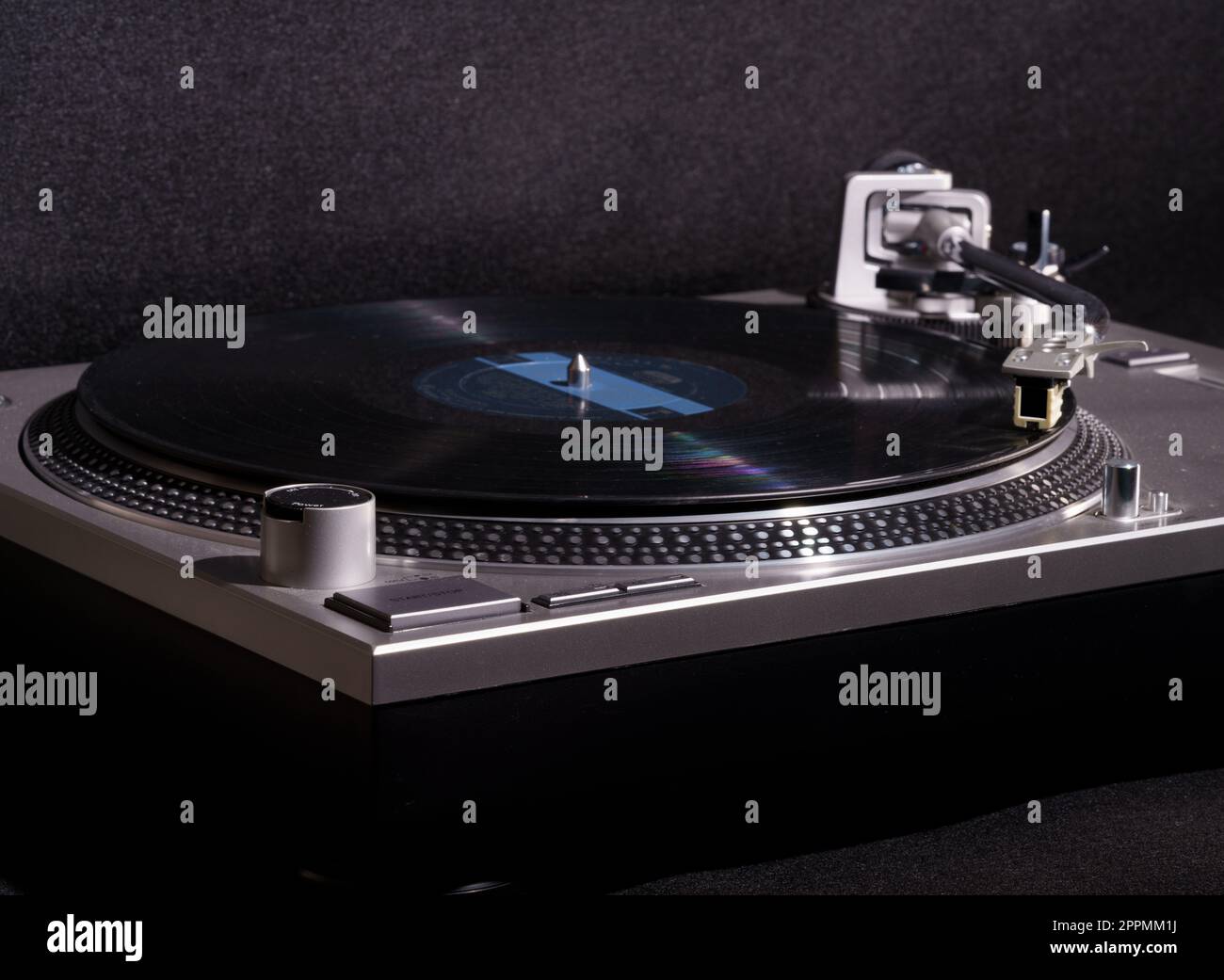 DJ's old school vinyl record playing on turntable in a dark party ...