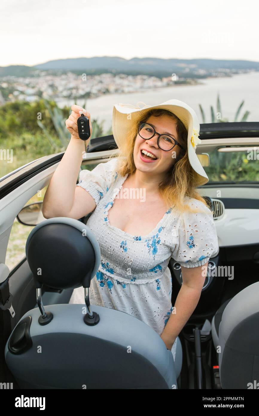Car driver woman smiling showing new car keys and car. Female driving ...