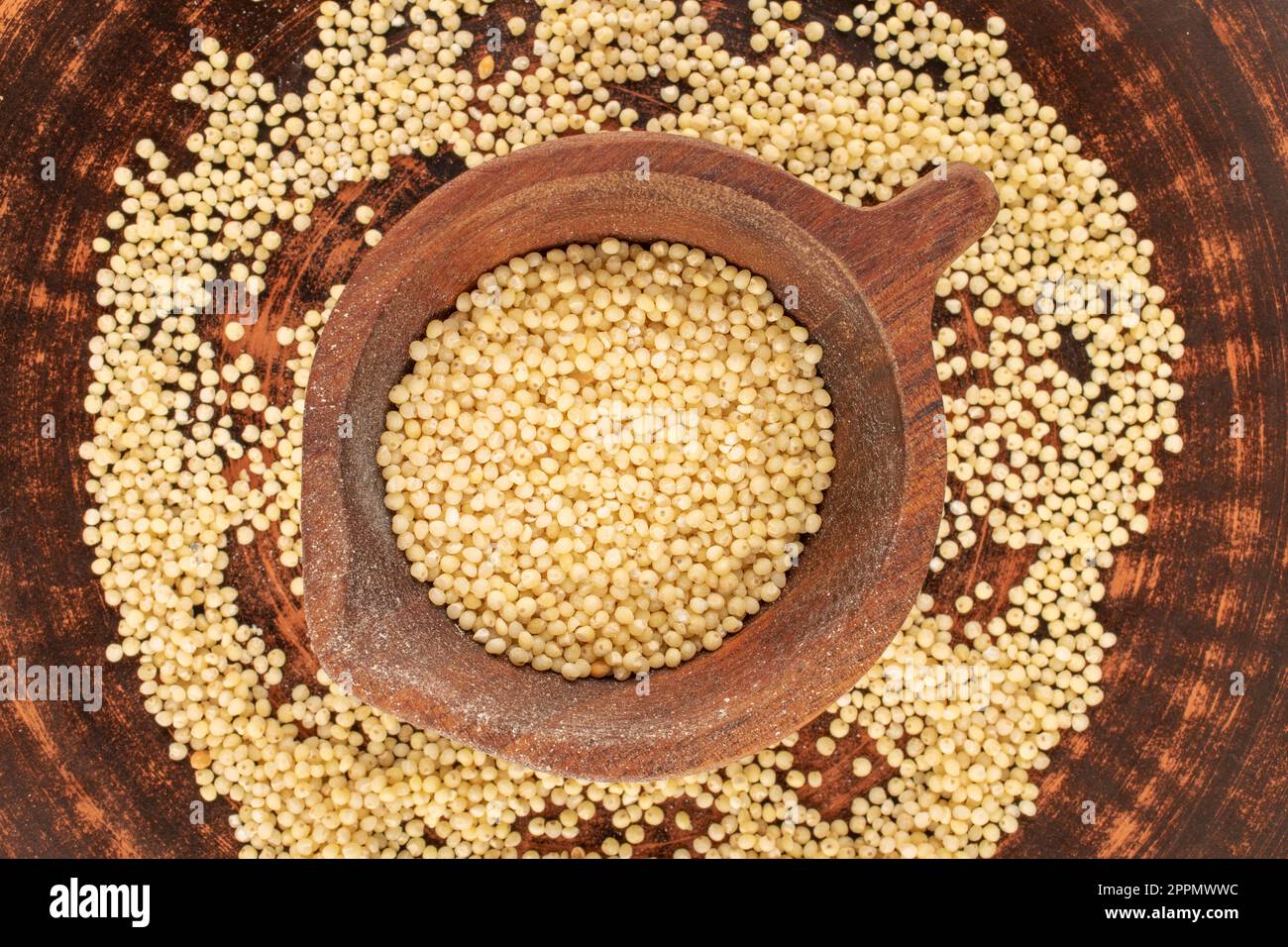 Millet in a wooden cup on a clay dish, macro, top view Stock Photo - Alamy