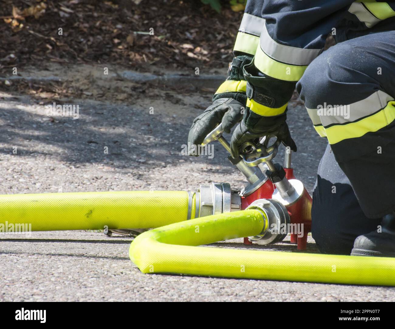 Fireman operating the valve of a firehose Stock Photo - Alamy