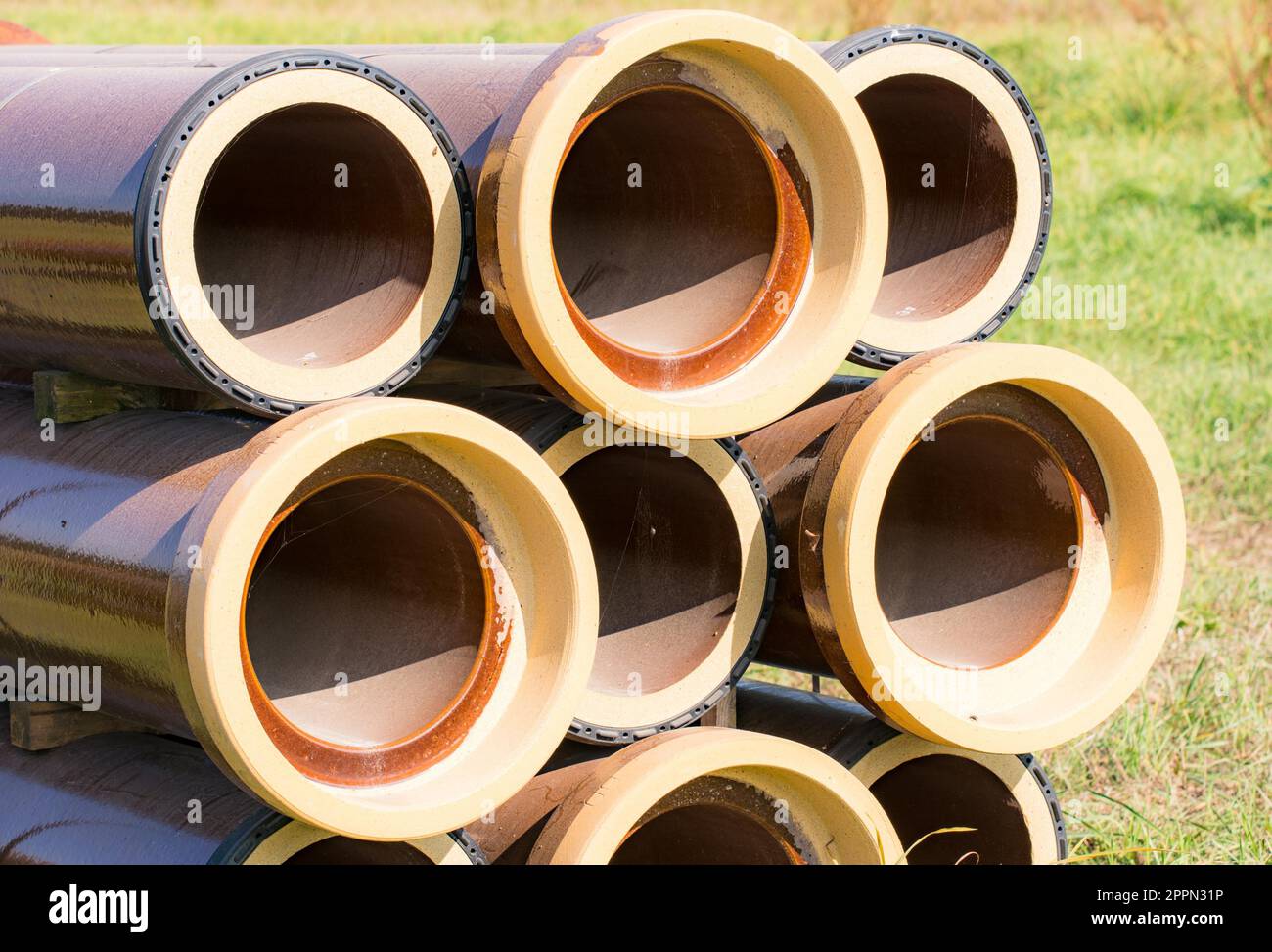 Stack of canalization pipes at a construction site Stock Photo - Alamy