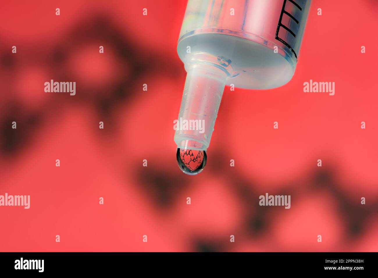 Love injection concept with a syringe an a heart refracting in a drop ...