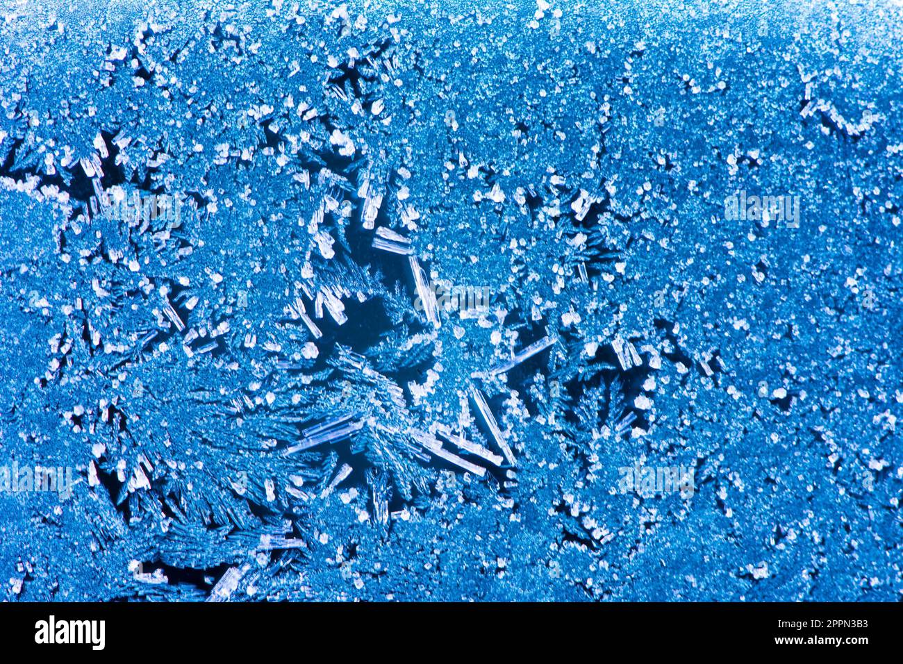Abstract macro background with ice crystals on a blue metallic surface ...