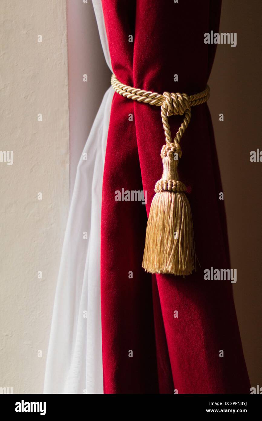 10.08.2021 Miclosoara Romania. Red velvet curtain with gold curtain ...