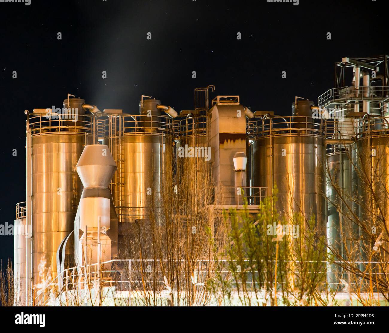 Illuminated Storage tanks of a chemical plant at night Stock Photo - Alamy
