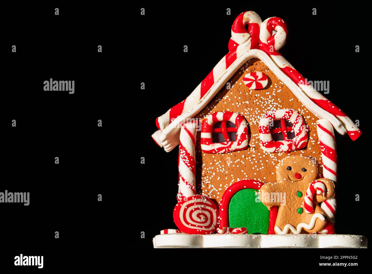 Cookies in the form of a house with a man, with a roof of lollipops on ...