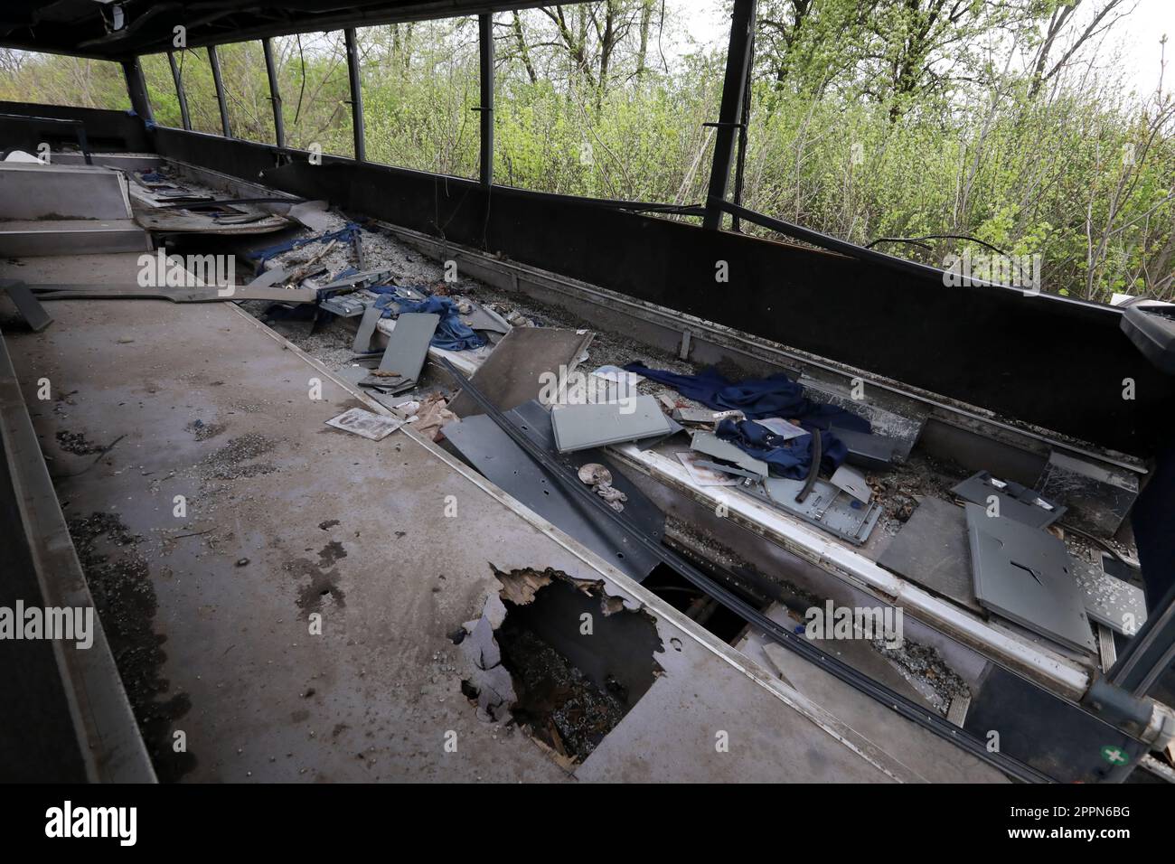 UKRAINE - APRIL 22, 2023 - A destroyed bus is left by the side of a ...