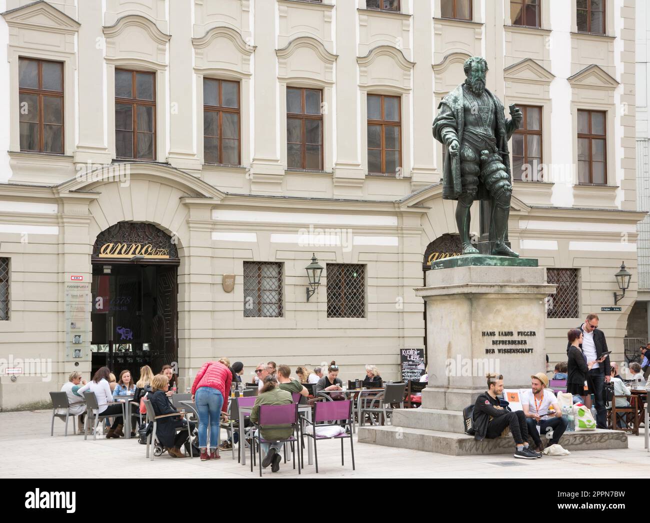 AUGSBURG, GERMANY - APRIL 1: Tourits at a street cafe at the Fugger ...