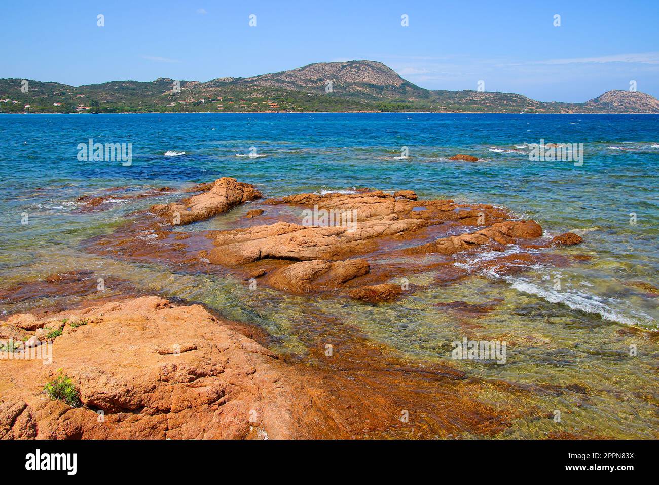 Semi-submerged rocks in the blue waters of the Mediterranean Sea on the ...