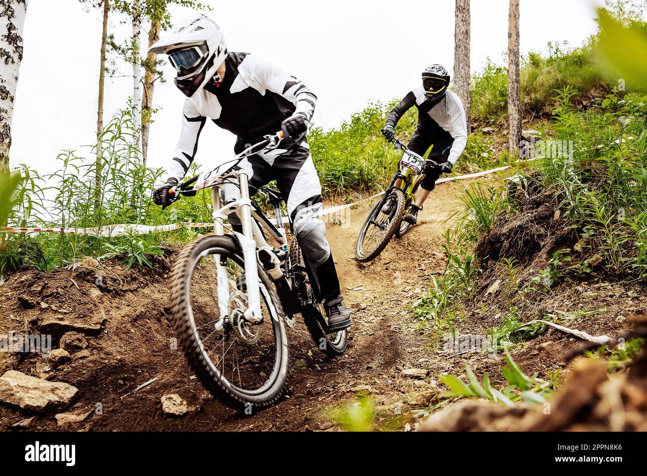 two racer athlete riding downhill training race in mountain bike ...
