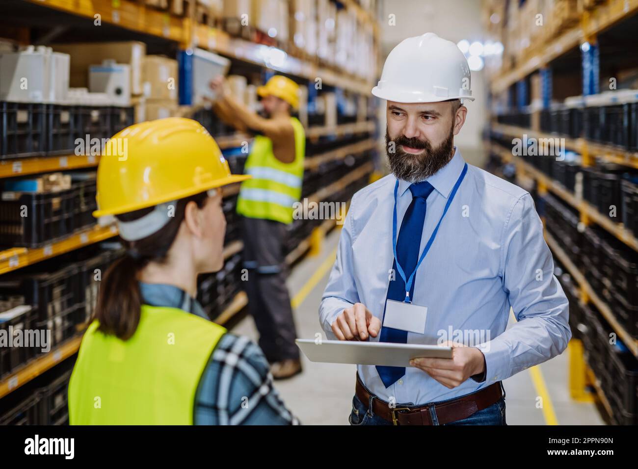 Manager explaining work to his employers in warehouse Stock Photo - Alamy