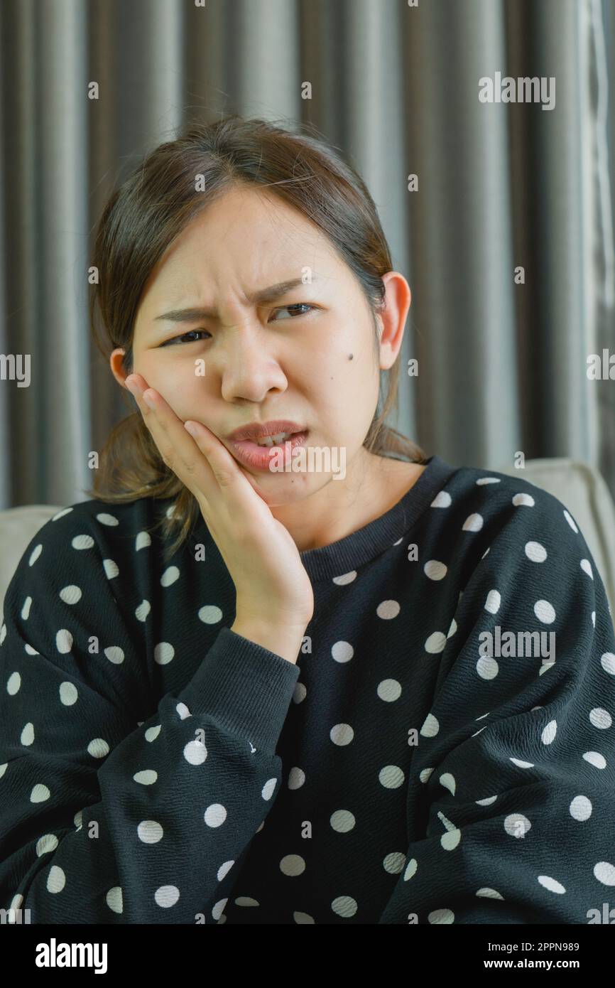 Closeup young woman touching her face and suffering from toothache ...