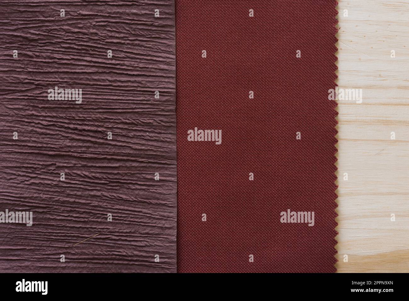 rough textured brown paper, red brown fabric sample, and wood surface ...