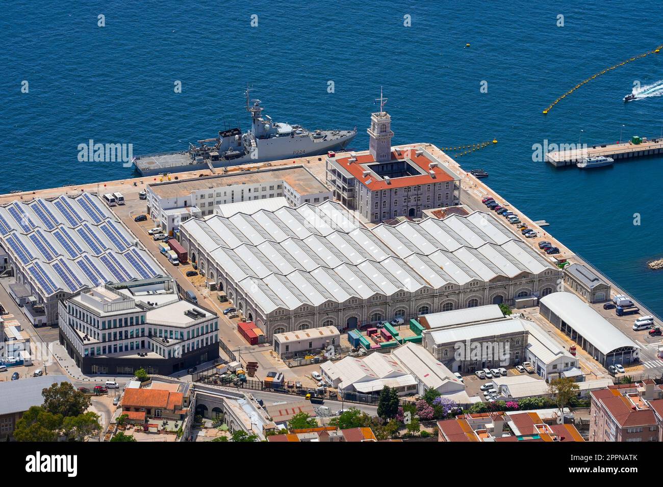 Military frigate moored next to maritime warehouses in the port of ...