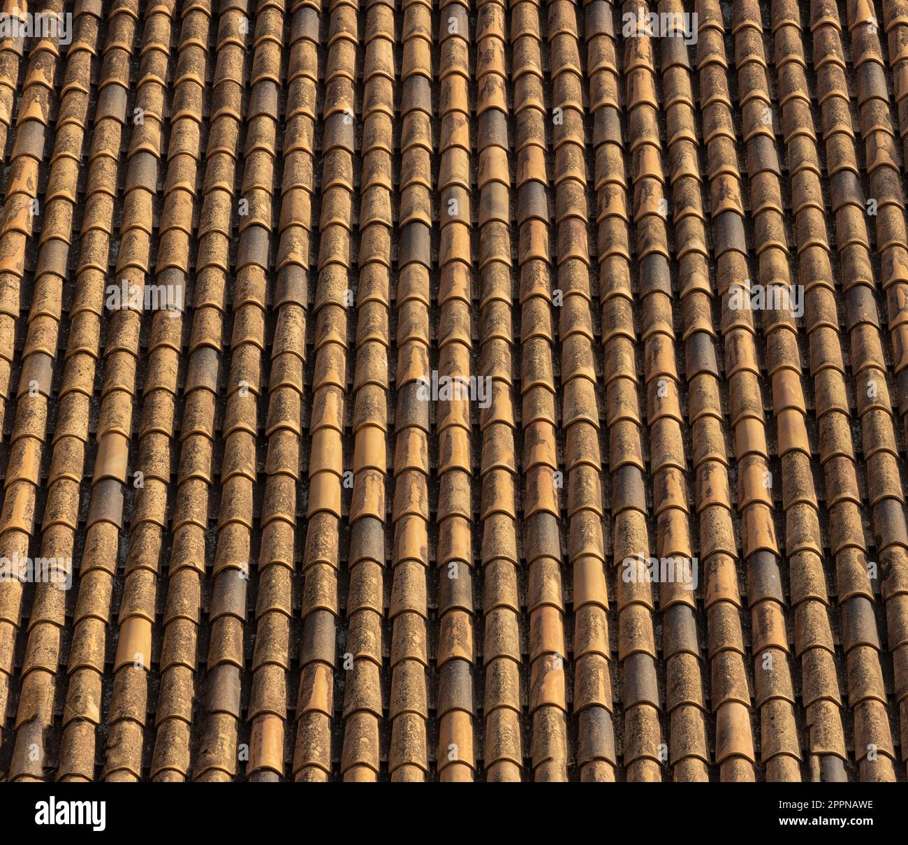 Old tile roof above the house and hard shadows from sunny in a summer ...