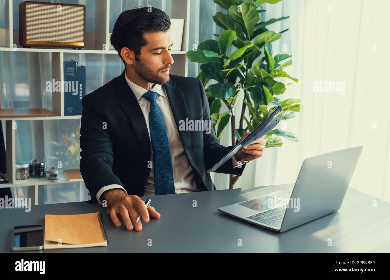 Modern professional businessman at modern office desk using laptop to ...