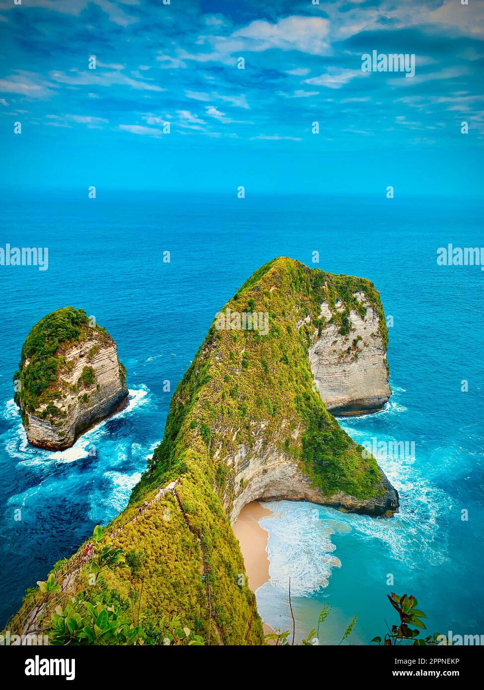 A tranquil beach scene featuring green cliffs with a crystal blue body ...