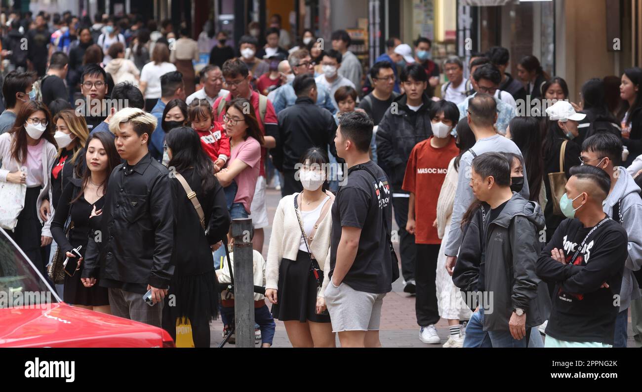 Shoppers walk along a street in Mong Kok during the Easter holidays ...