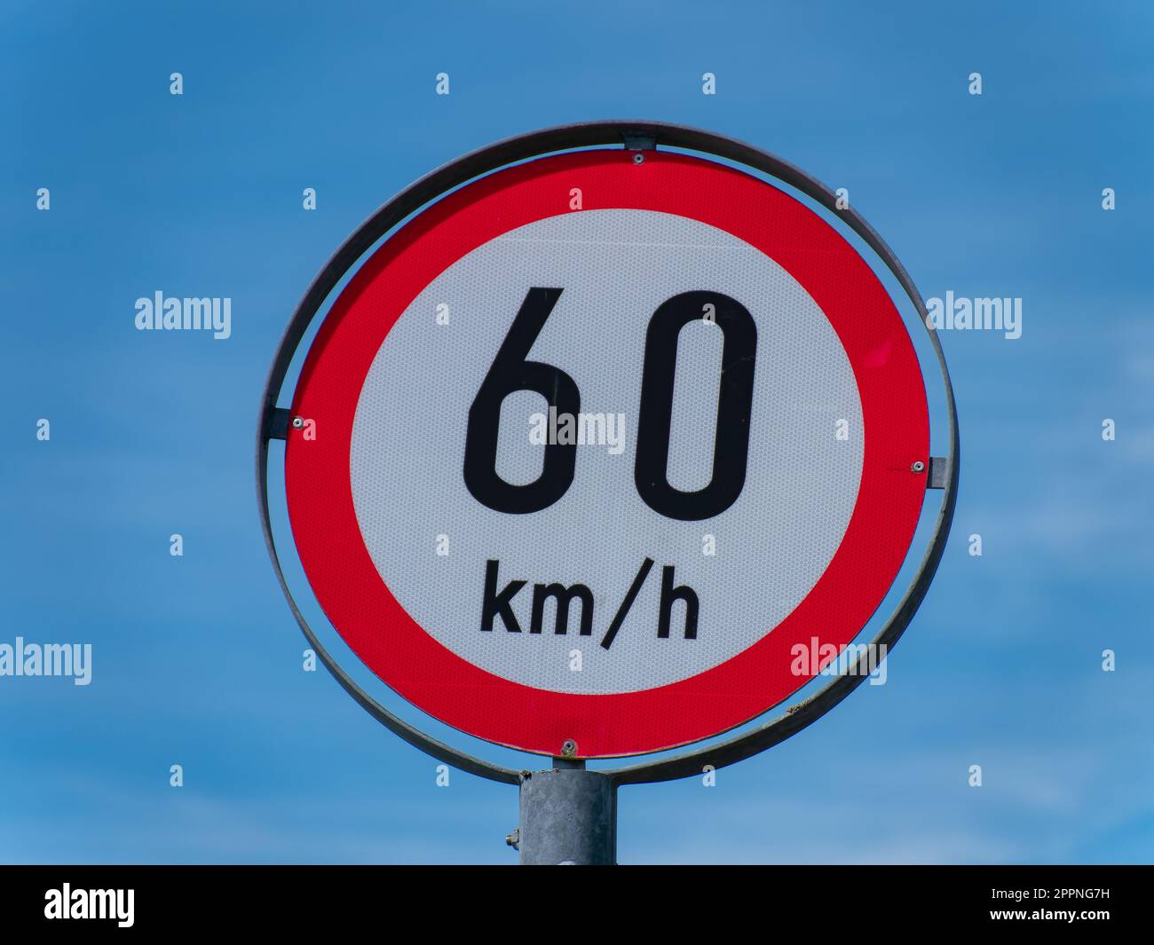 A road sign limiting the speed to 60 km h on a blue sky background ...