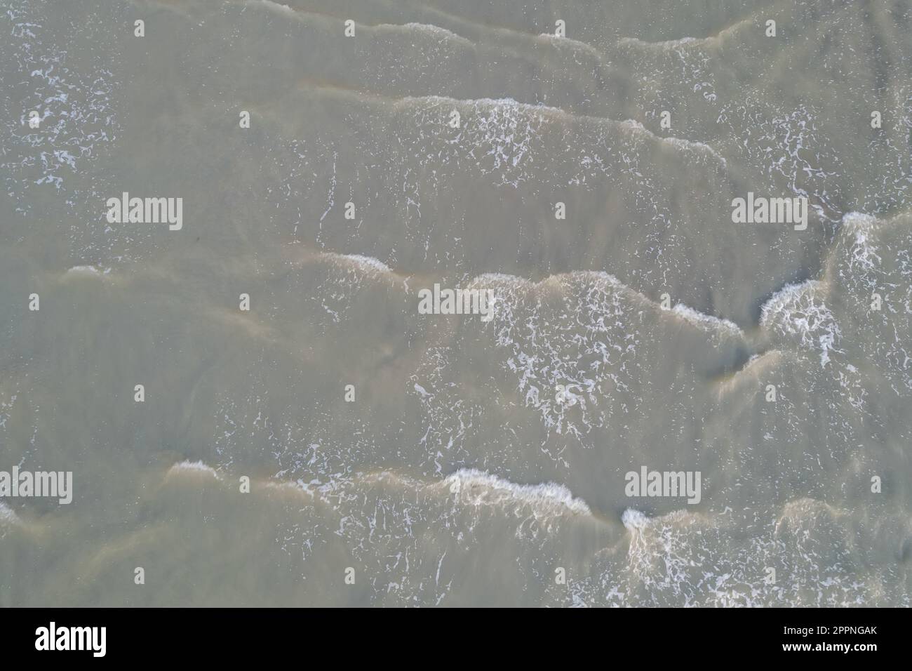 The surface of the sea in shallow water with waves and muddy water ...