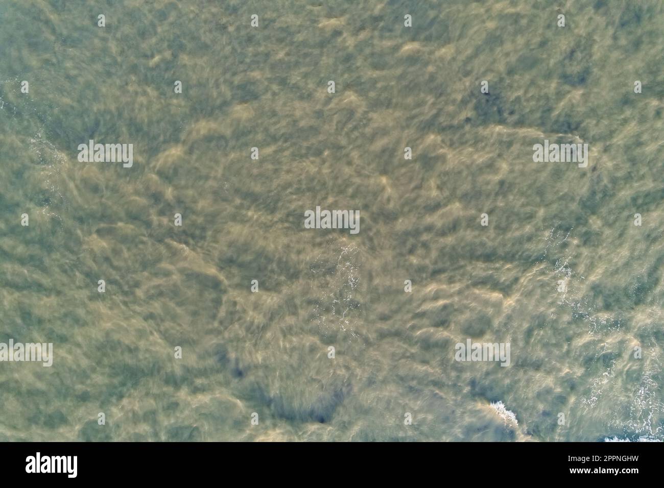The surface of the sea in shallow water with waves and muddy water ...