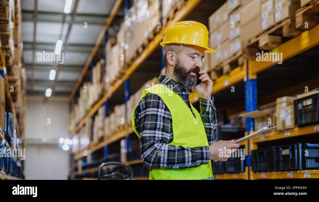 Warehouse worker checking up stuff in a warehouse Stock Photo - Alamy