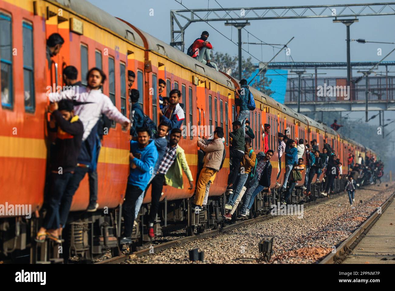 Indian passengers cling to a crowded train as it leaves Noli station in ...