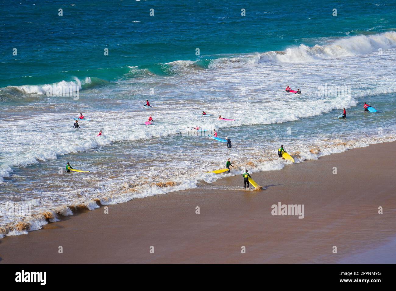 Students of a surfing school in the waves of the Playa del Castillo ...