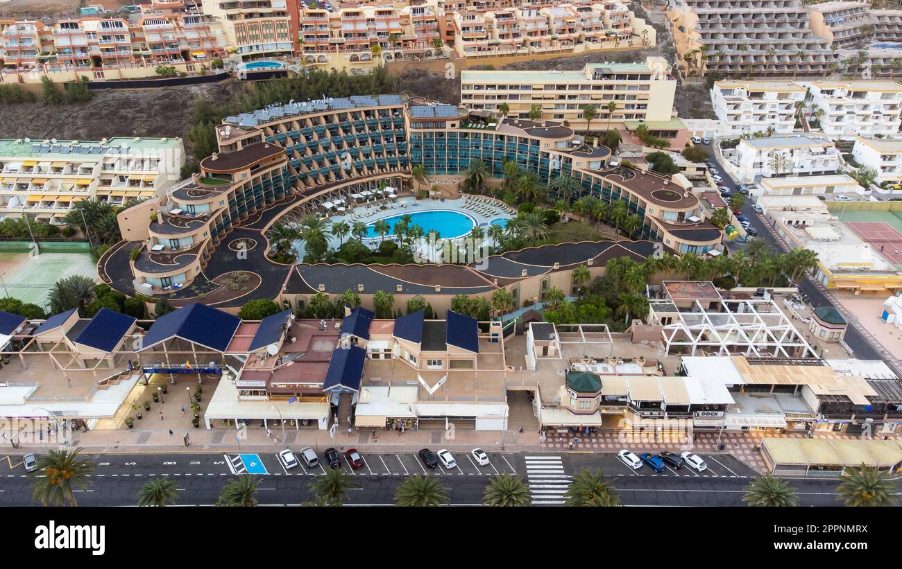 Aerial view of a circular resort built around a pool next to the ...