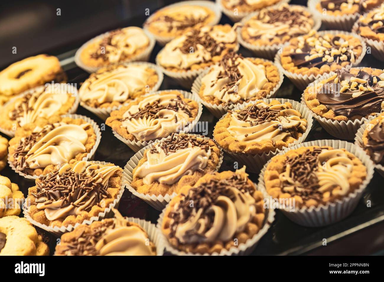 A colorful photo of various desserts and pastries in a bakery window ...