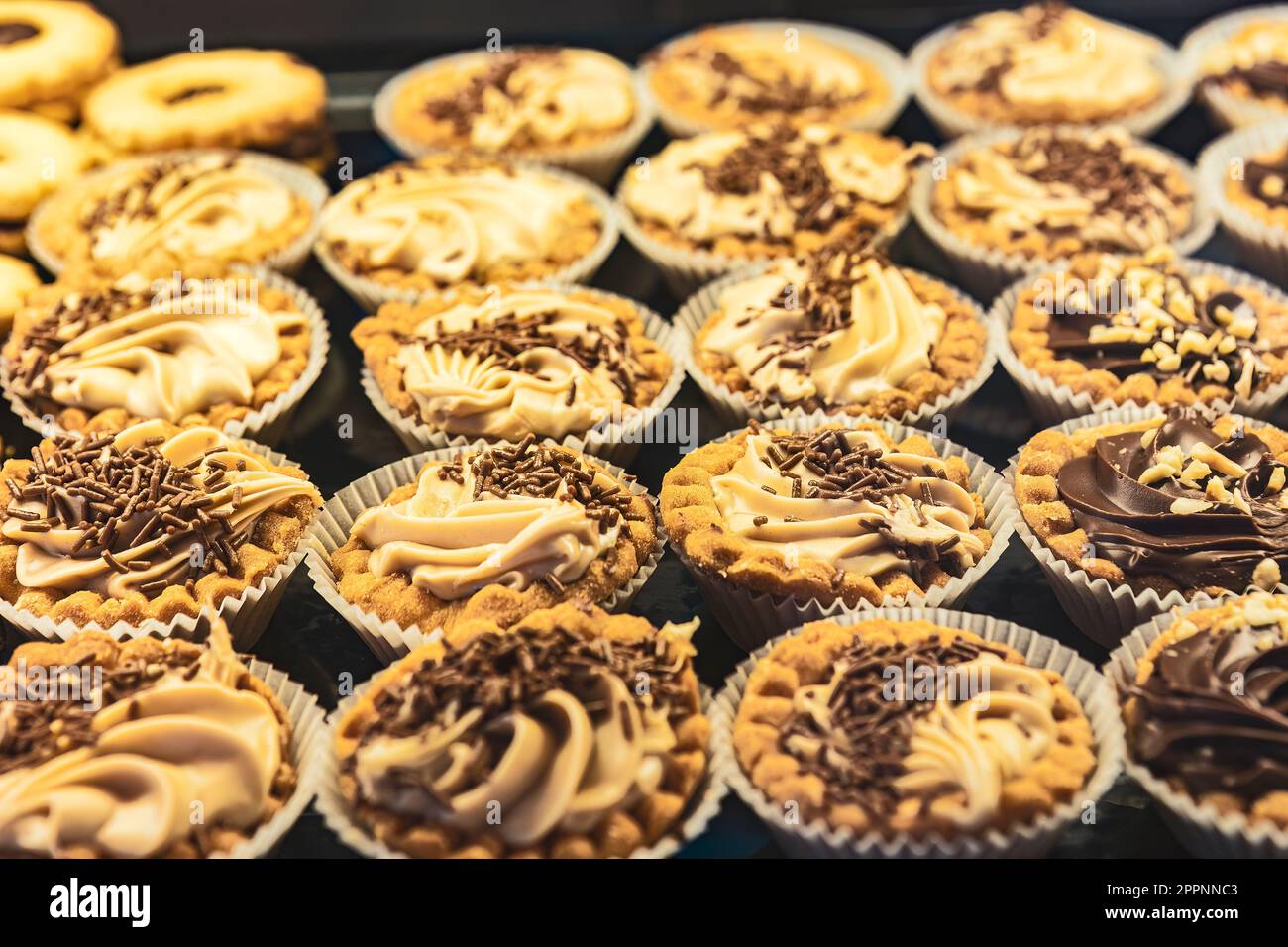 A colorful photo of various desserts and pastries in a bakery window ...