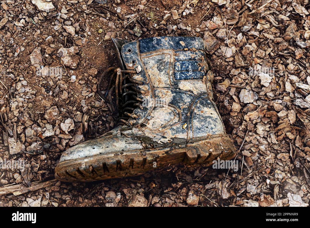 one soldier's boot in the mud. dirty boots on the ground. Losses in ...