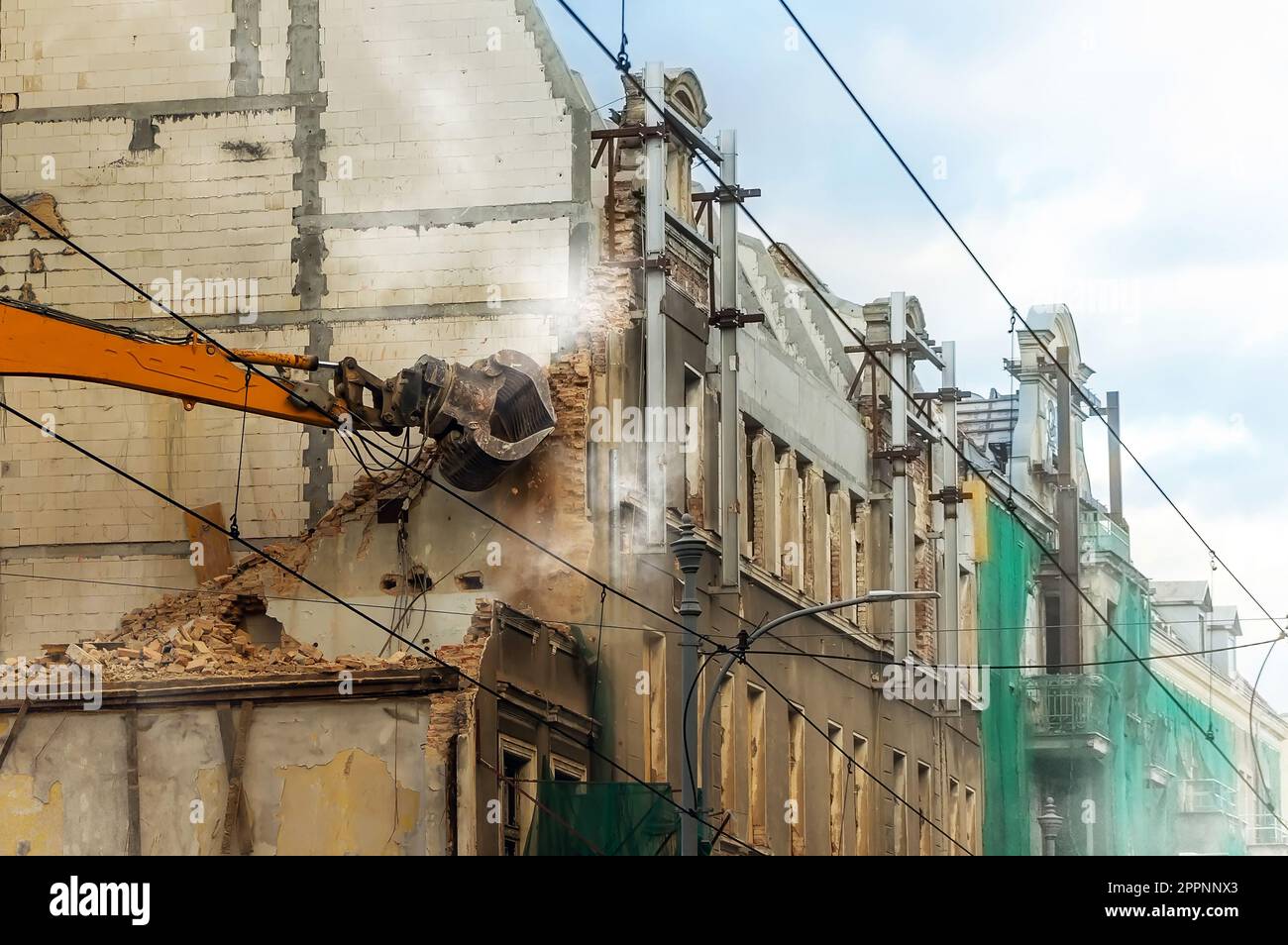 Dismantling of building walls. hydraulic crushing machine breaks house ...