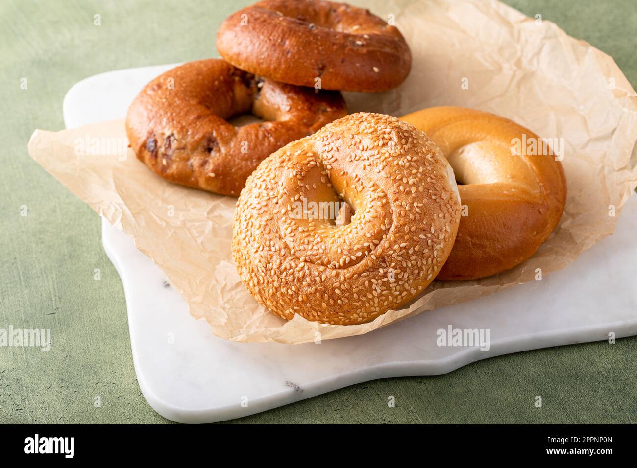Homemade freshly baked bagels on a parchment paper ready to eat ...
