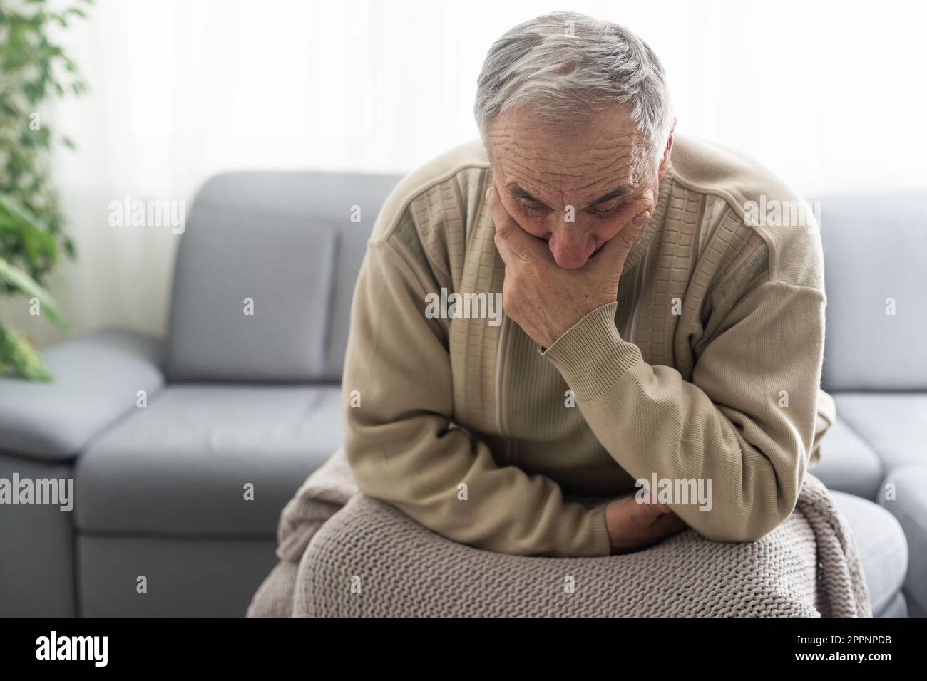 Frustrated unhappy middle aged mature man sitting on sofa, feeling ...