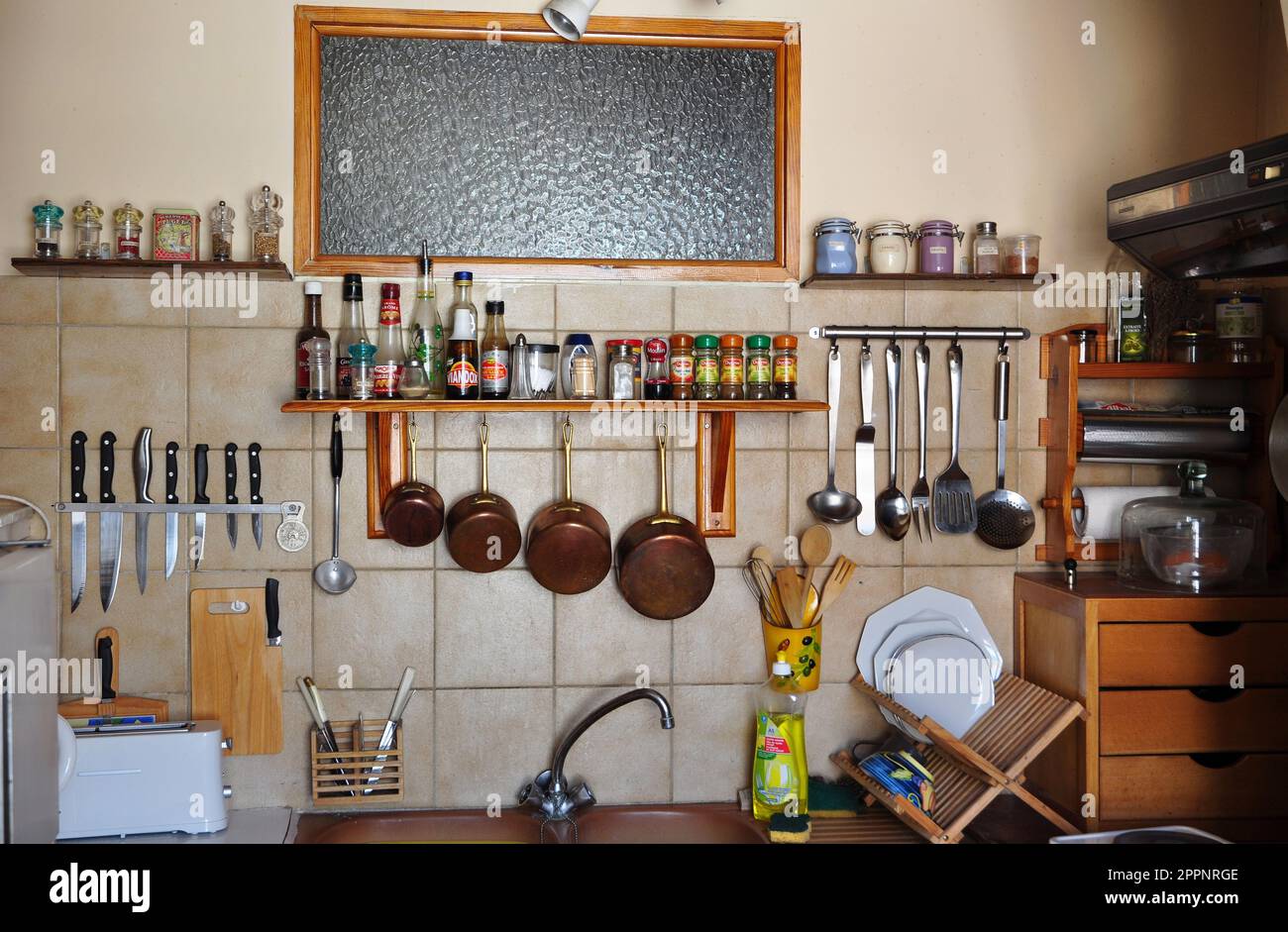 A tidy single kitchen with hanging kitchen utensils Stock Photo - Alamy