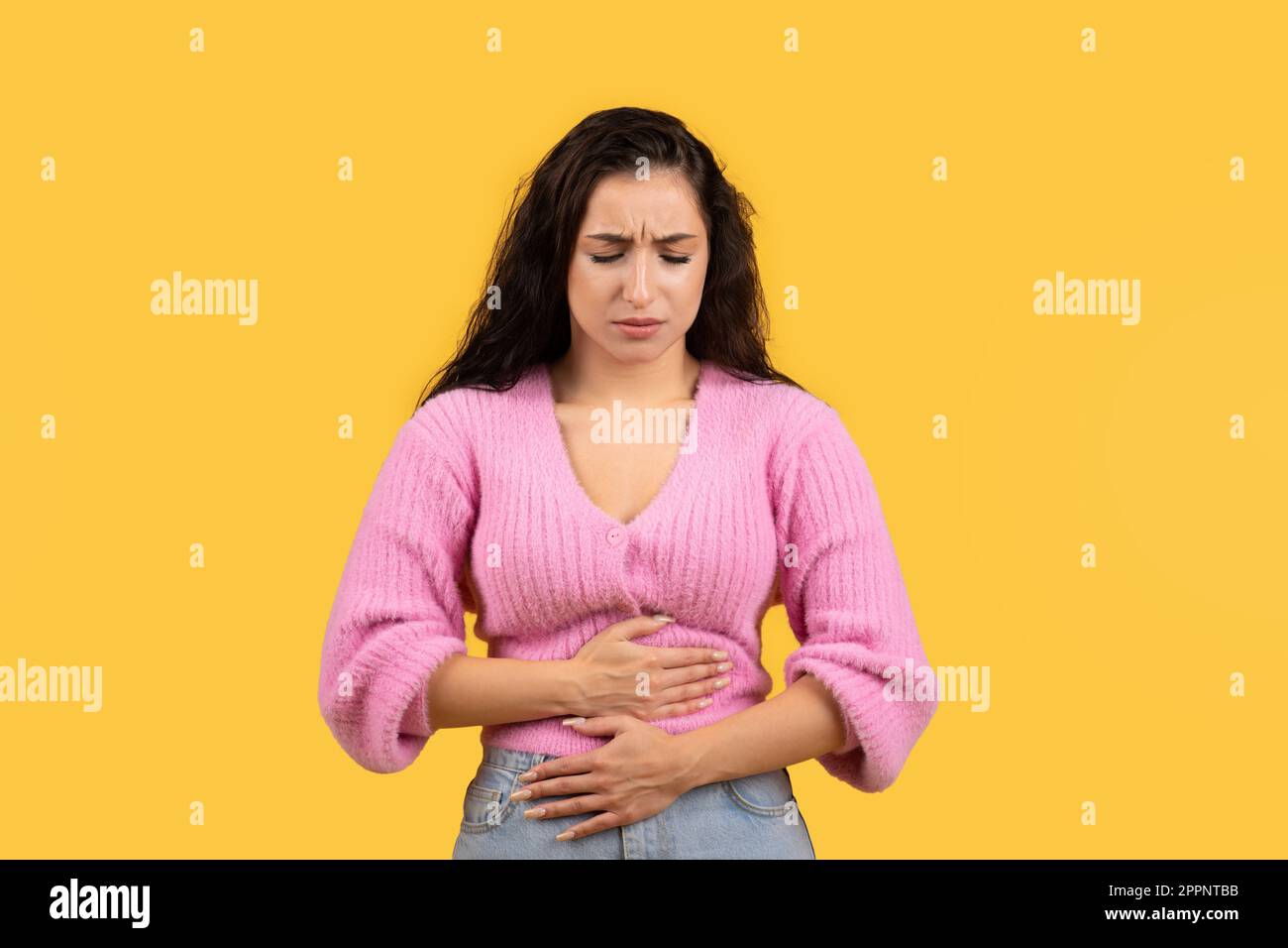 Sad millennial arab lady presses her hands to belly, suffering from ...