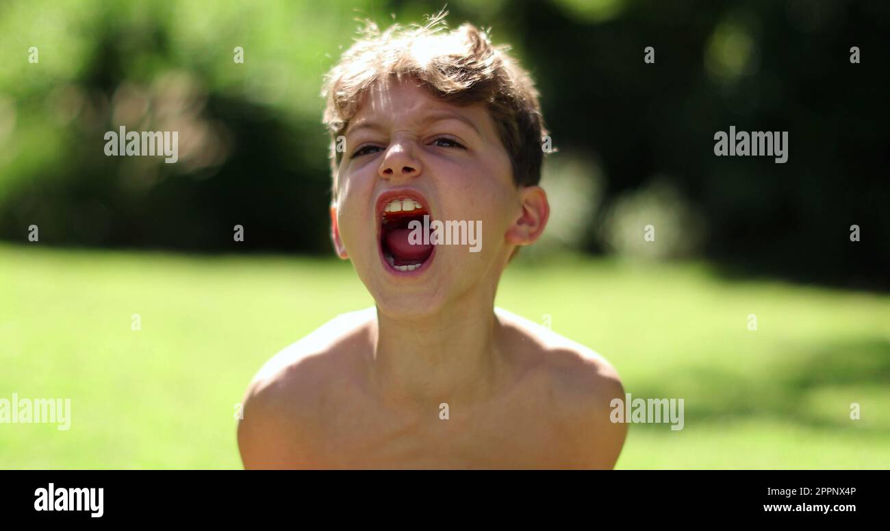 Child boy screaming from top of his lungs in slow-motion. Angry kid ...