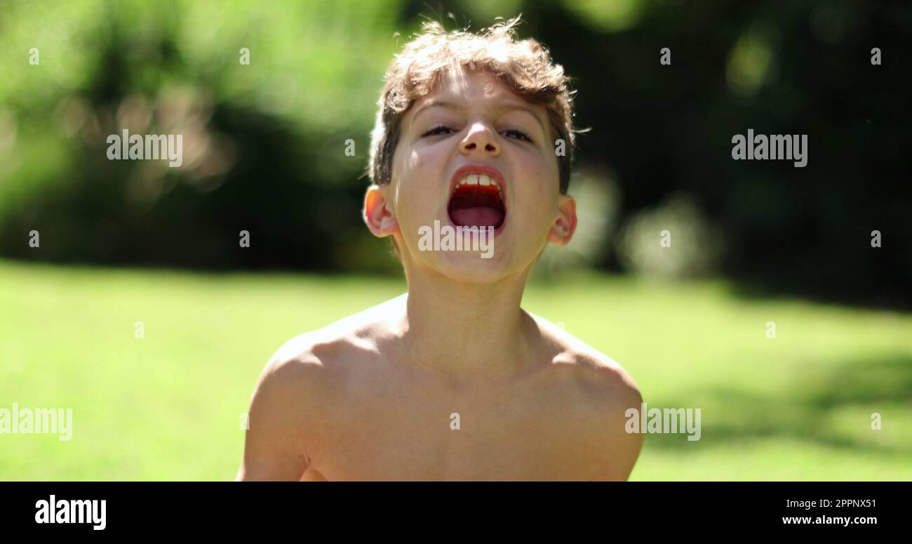 Child boy screaming from top of his lungs in slow-motion. Angry kid ...